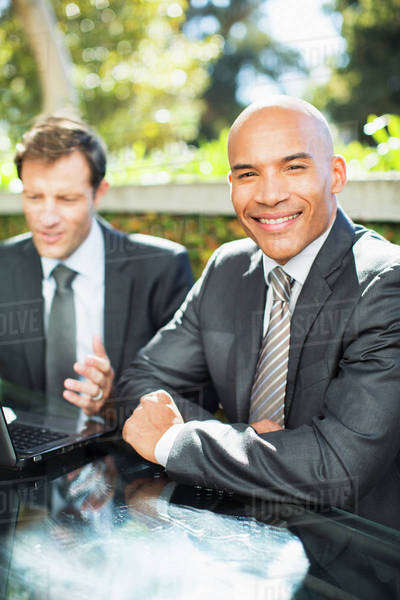 Businessman smiling outdoors - Stock Photo - Dissolve