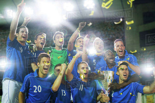 Soccer team celebrating with trophy on field - Royalty-free Stock Photo ...