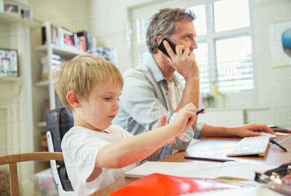 Father and son working in home office - Royalty-free Stock Photo | Dissolve