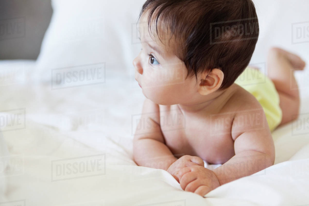 Baby girl laying on bed - Royalty-free Stock Photo | Dissolve