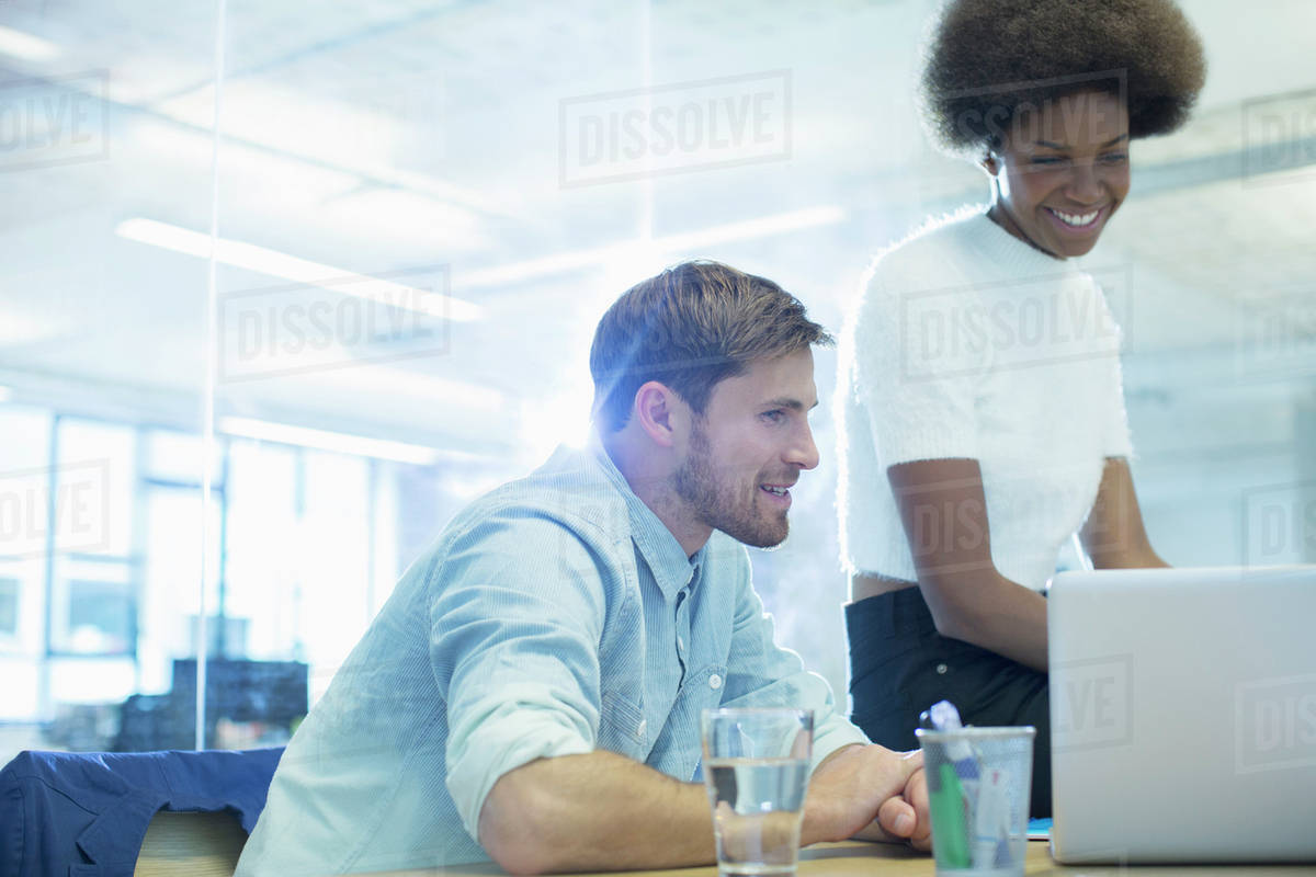Business people using laptop in office - Stock Photo - Dissolve