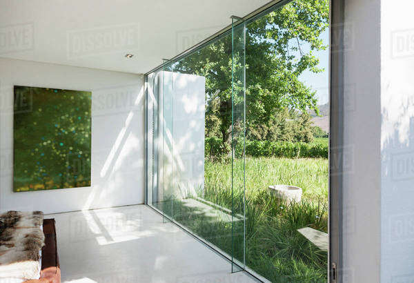 Modern house with glass walls overlooking grass - Royalty-free Stock ...