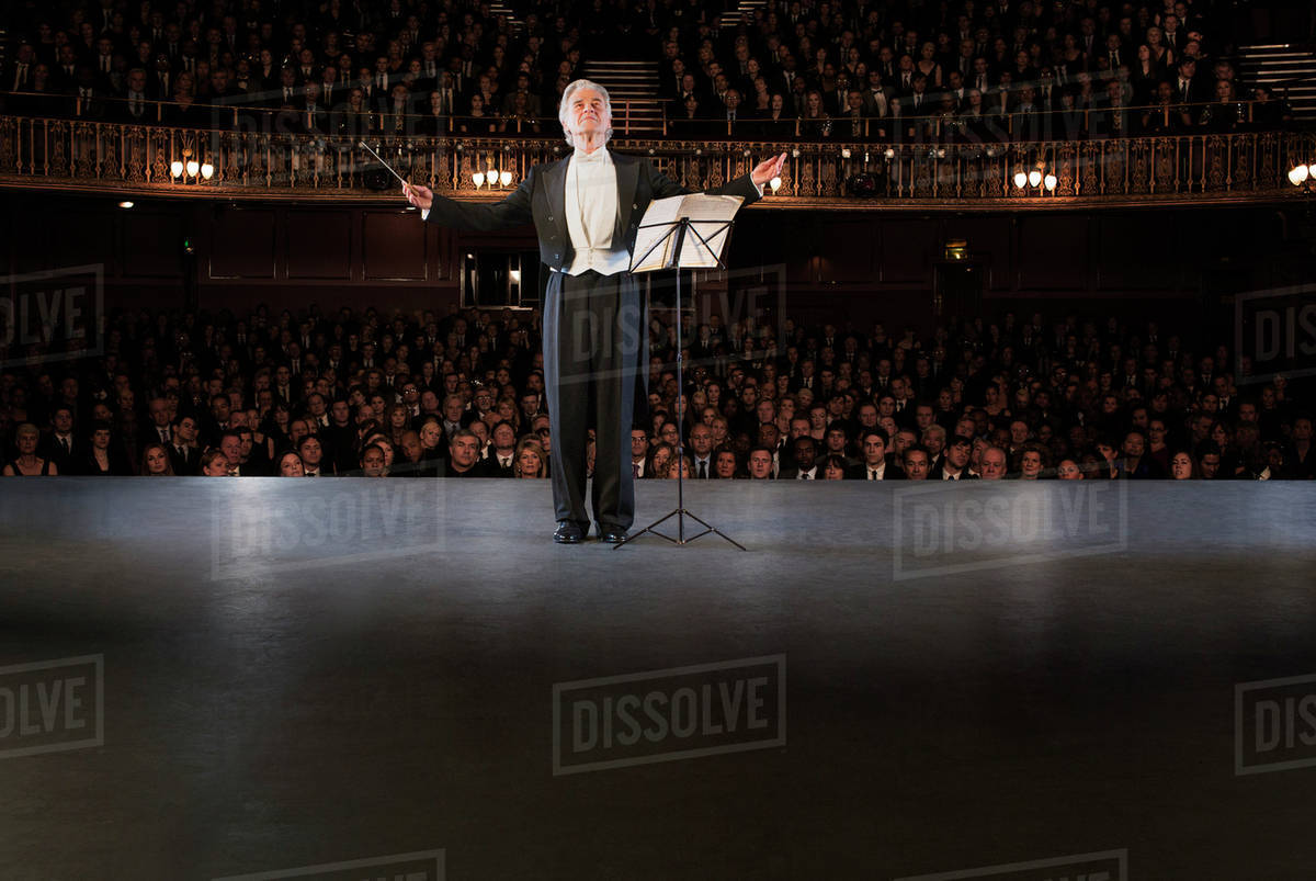 Conductor performing on stage in theater - Stock Photo - Dissolve