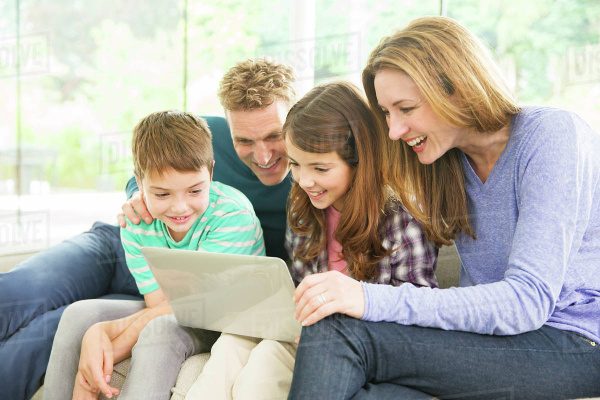 Family using laptop in living room - Royalty-free Stock Photo | Dissolve