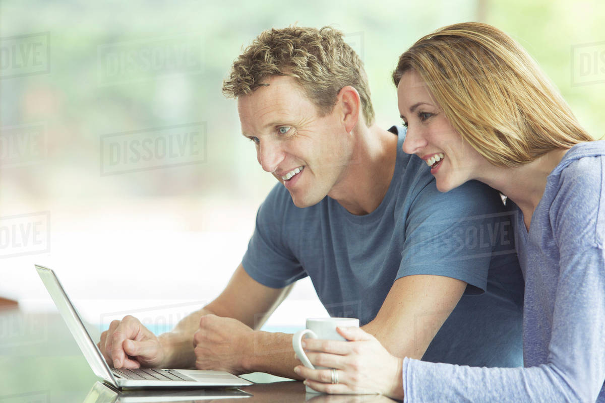 Couple using laptop together - Royalty-free Stock Photo | Dissolve