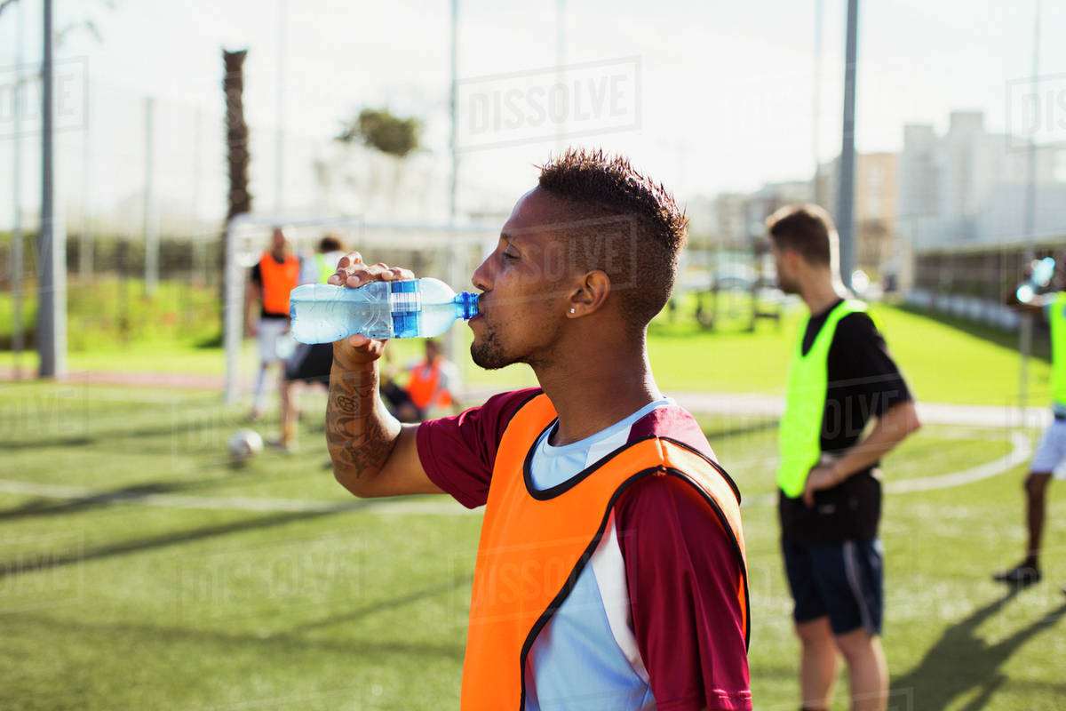Soccer player drinking water on field - Royalty-free Stock Photo | Dissolve