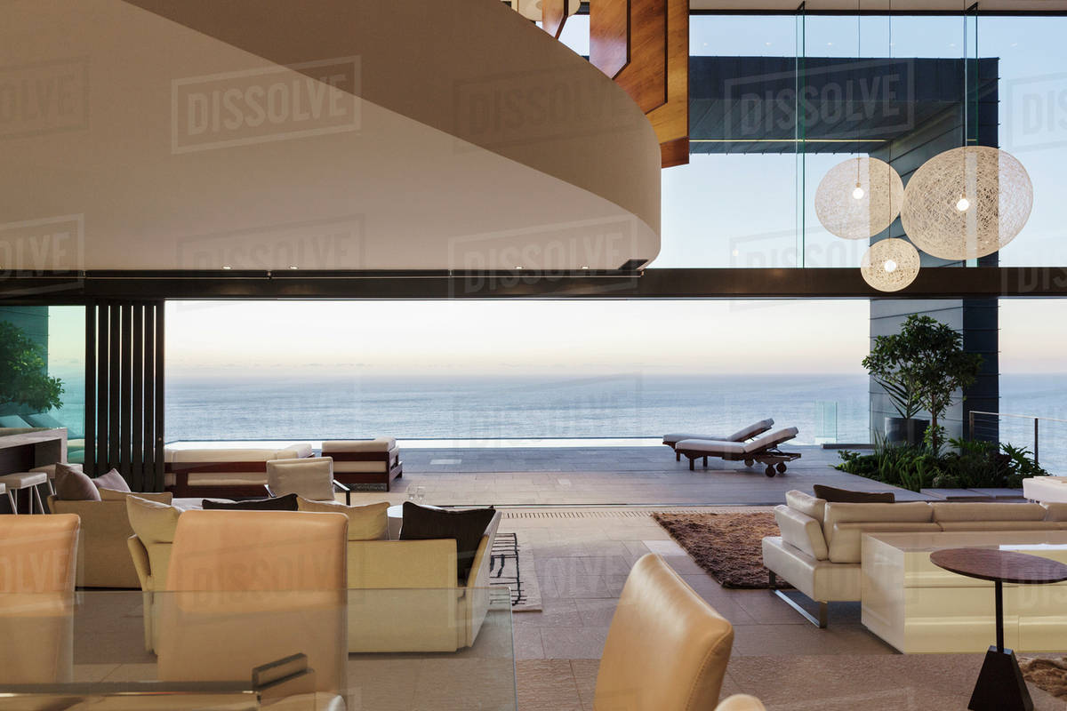 Modern living room overlooking ocean at sunset - Royalty-free Stock ...
