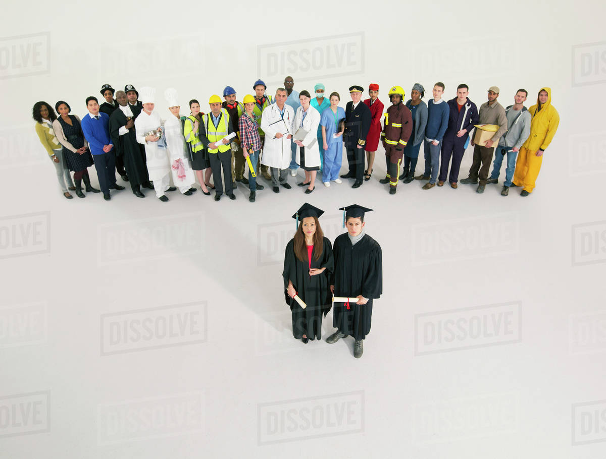 Portrait of graduates with workers in background - Stock Photo - Dissolve