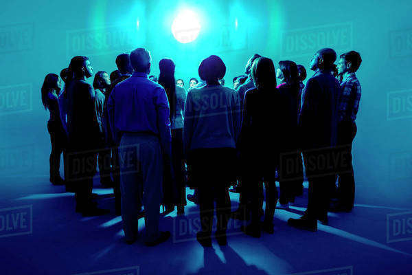 Crowd standing around bright light - Royalty-free Stock Photo | Dissolve