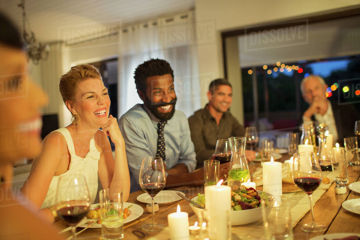 Friends laughing at dinner party - Royalty-free Stock Photo | Dissolve