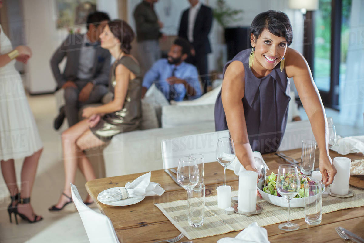 Woman serving food at dinner party - Royalty-free Stock Photo | Dissolve