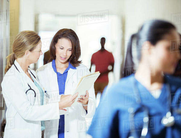Doctors reading medical chart in hospital hallway - Royalty-free Stock ...