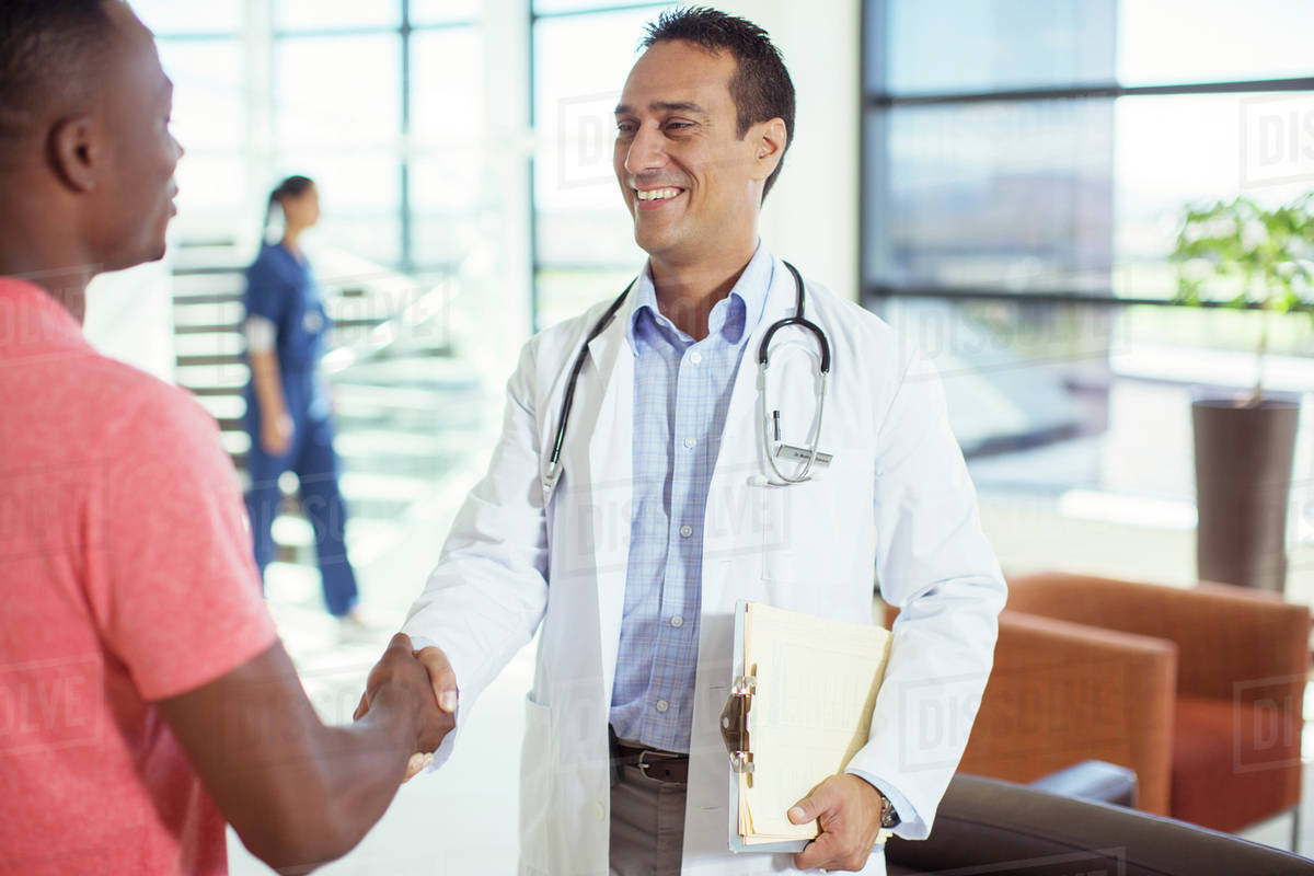 Doctor and patient shaking hands in hospital - Stock Photo - Dissolve