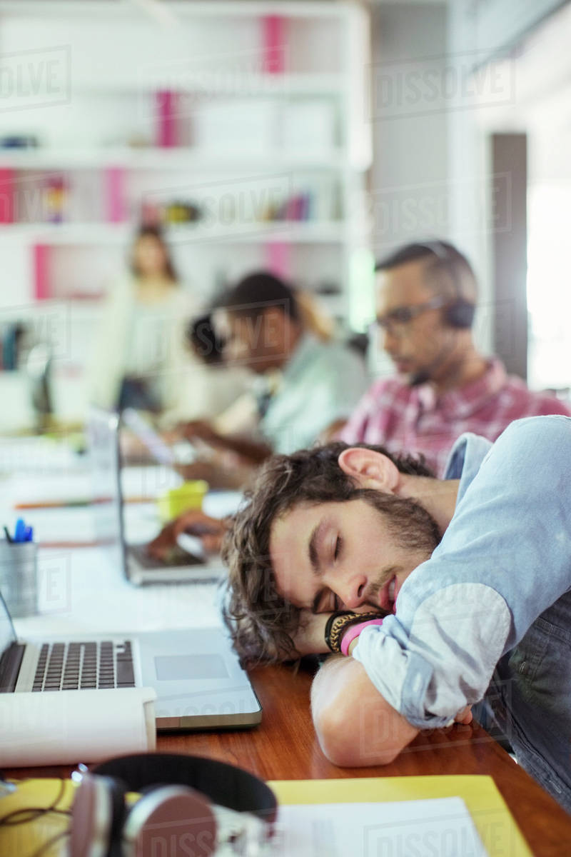 Man sleeping at desk in office - Royalty-free Stock Photo | Dissolve