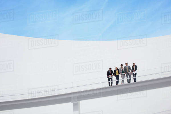 Portrait of business people at railing of elevated walkway - Royalty ...