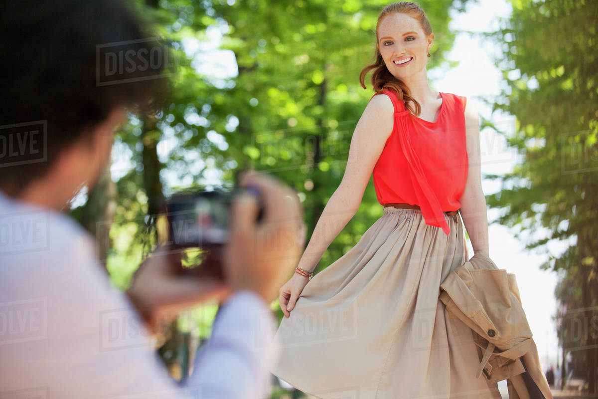 Man photographing woman in park - Royalty-free Stock Photo | Dissolve