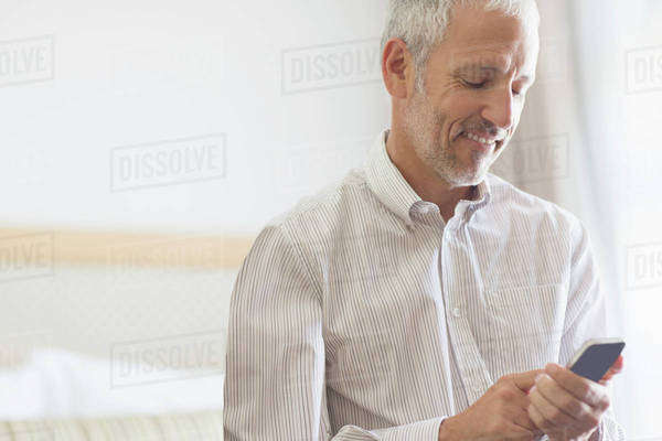 Businessman using cell phone in hotel room - Royalty-free Stock Photo ...