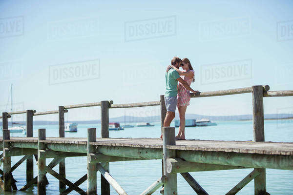 Couple hugging on wooden dock - Royalty-free Stock Photo | Dissolve