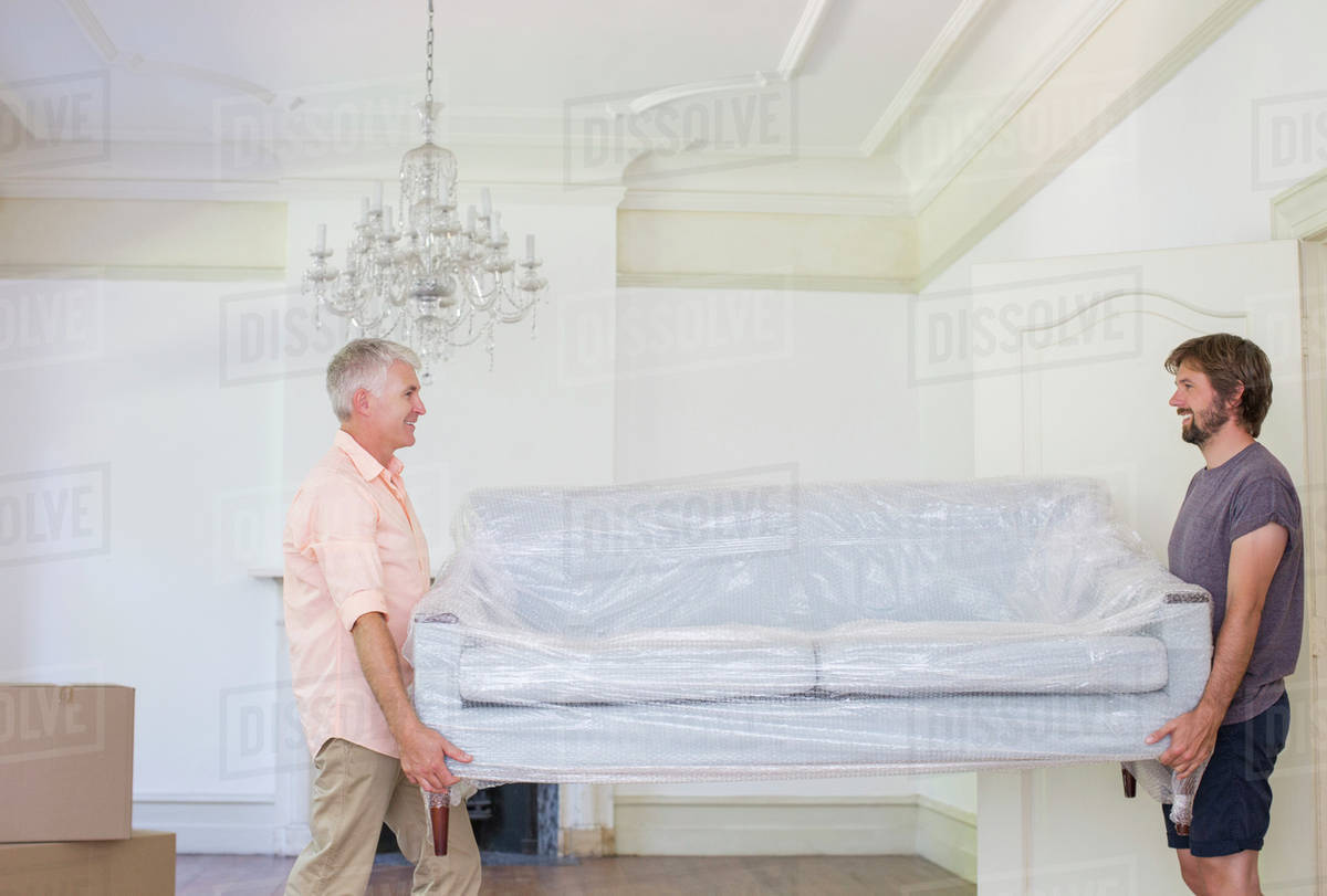 Father and son carrying couch into living space - Royalty-free Stock ...