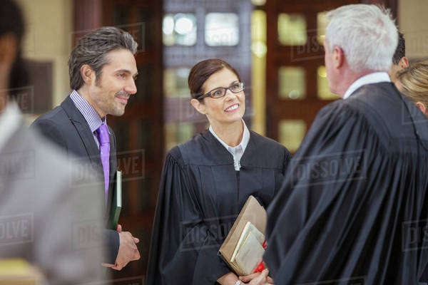 Judges and lawyers talking outside courtroom - Stock Photo - Dissolve