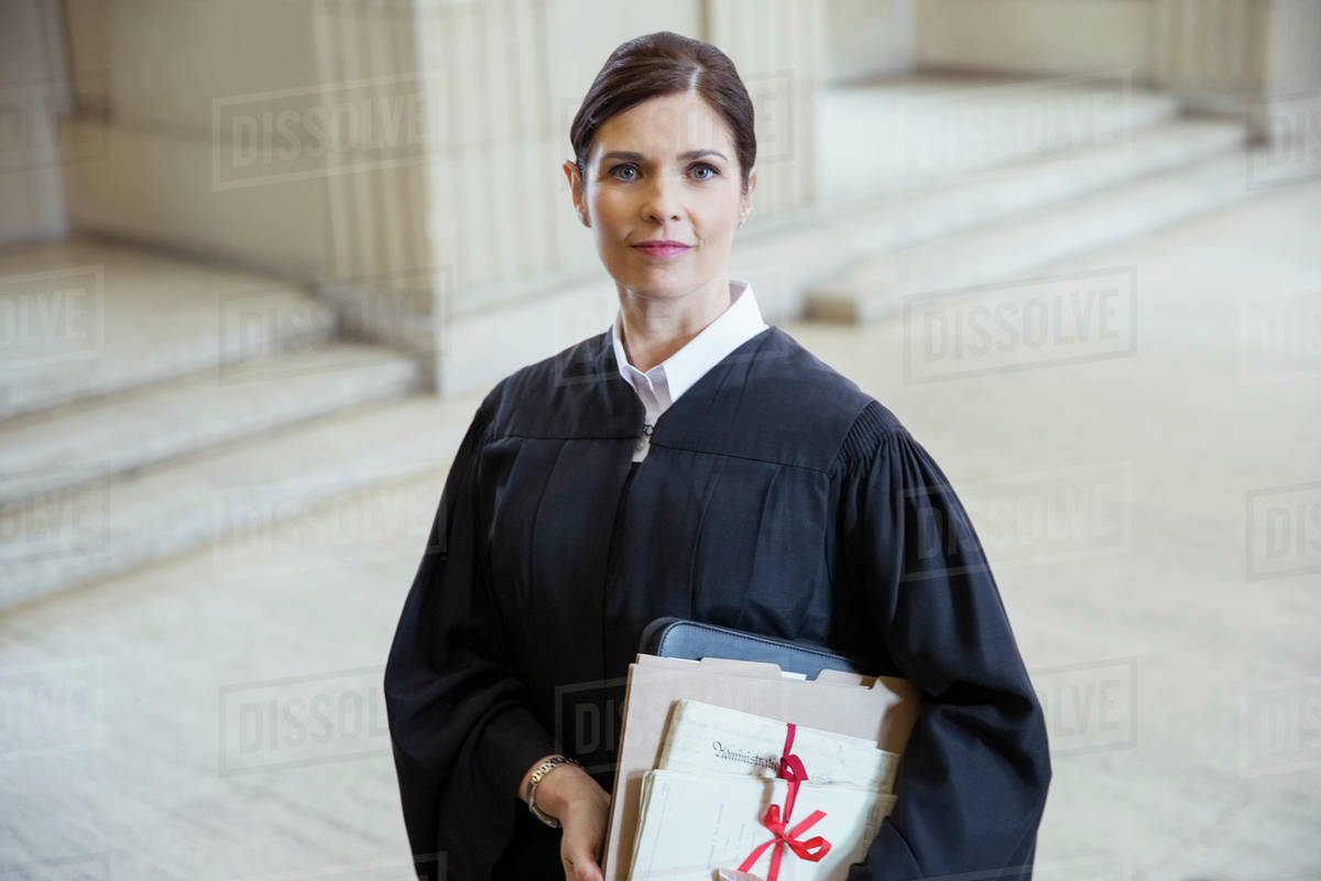 Judge holding legal documents in courthouse - Stock Photo - Dissolve