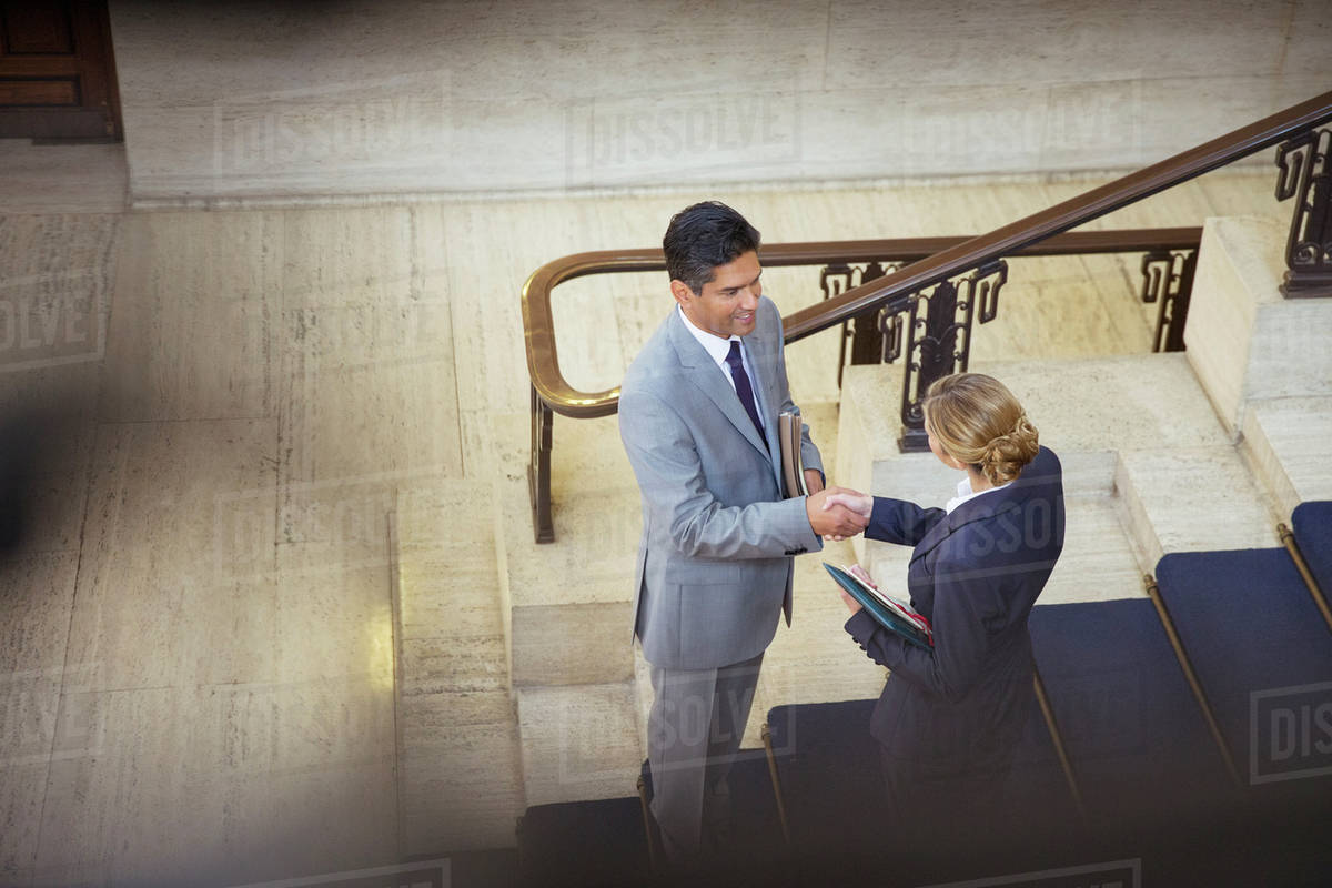 Lawyers shaking hands in courthouse - Royalty-free Stock Photo | Dissolve