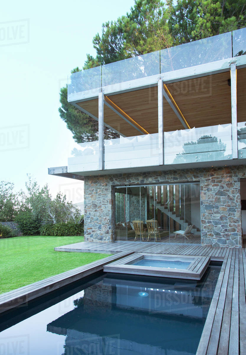 Modern house overlooking swimming pool and wooden deck - Royalty-free ...