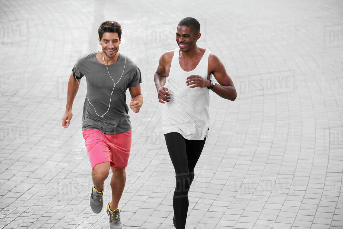 Men running through city streets together - Stock Photo - Dissolve