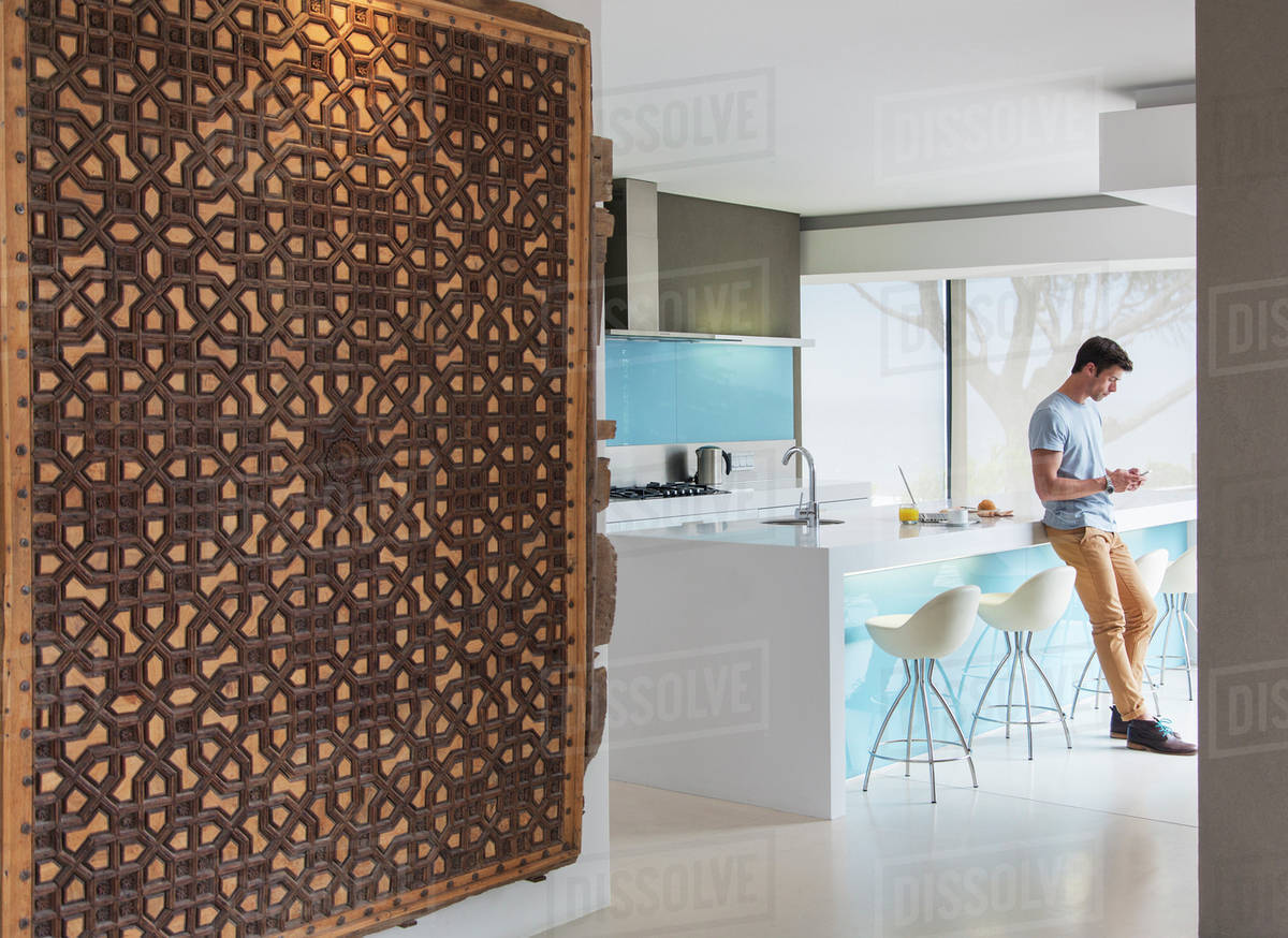 Man leaning against kitchen counter and texting - Royalty-free Stock ...