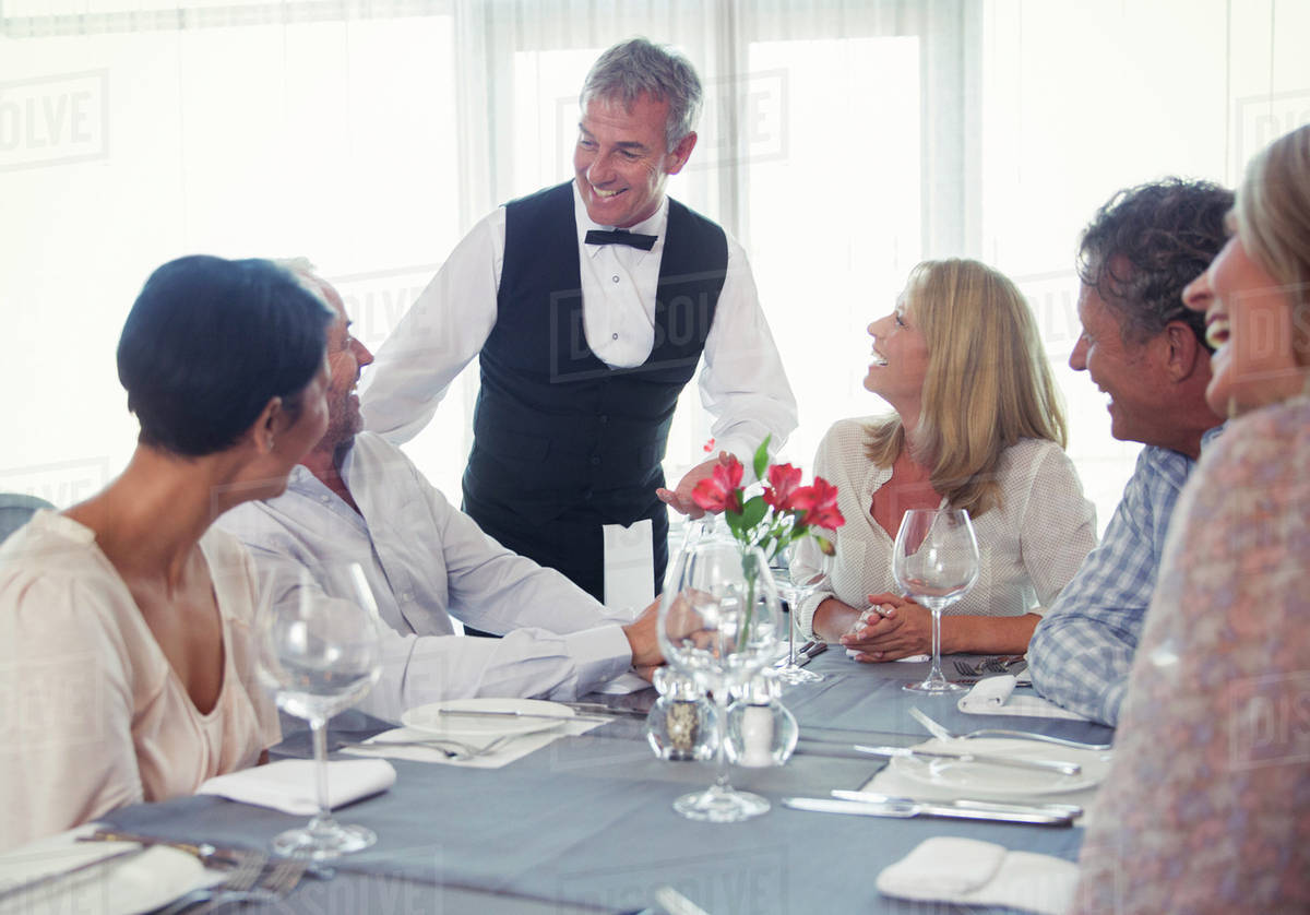 People sitting at restaurant table and talking to waiter - Royalty-free ...