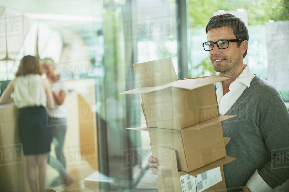 Businessman carrying cardboard boxes in office - Royalty-free Stock ...