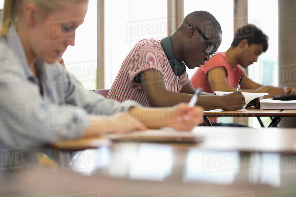 View of students sitting at desks during test in classroom - Royalty ...