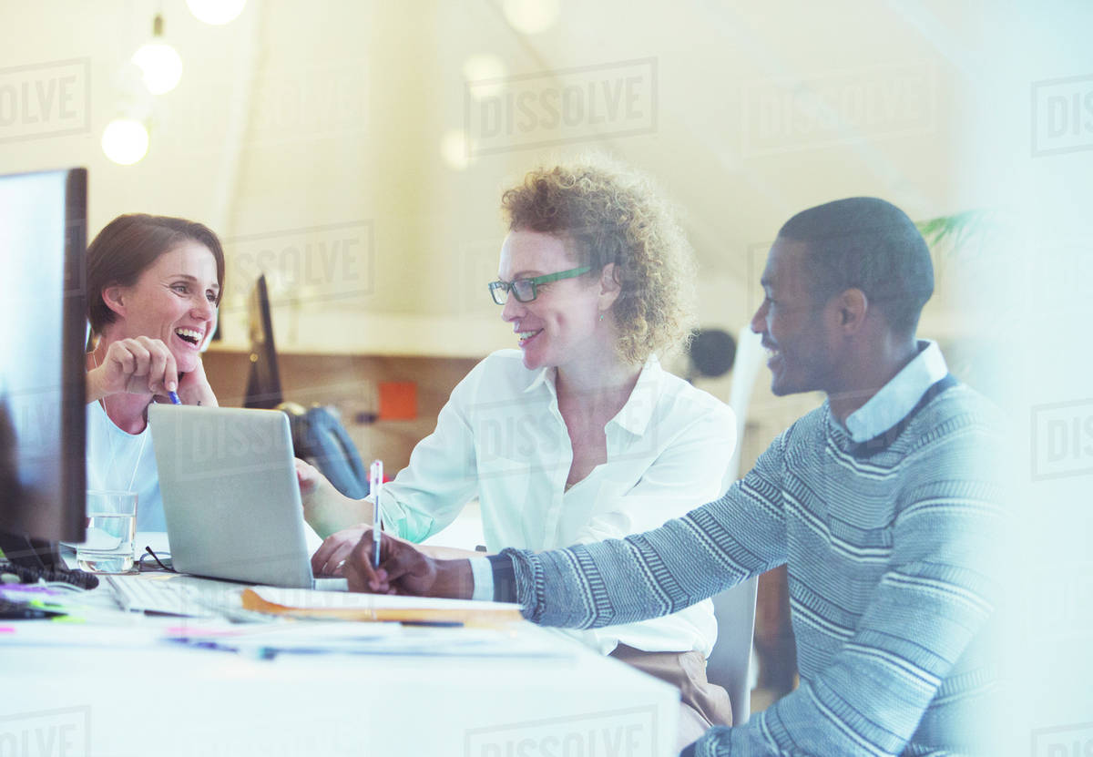 Office workers talking over laptop at desk - Royalty-free Stock Photo ...