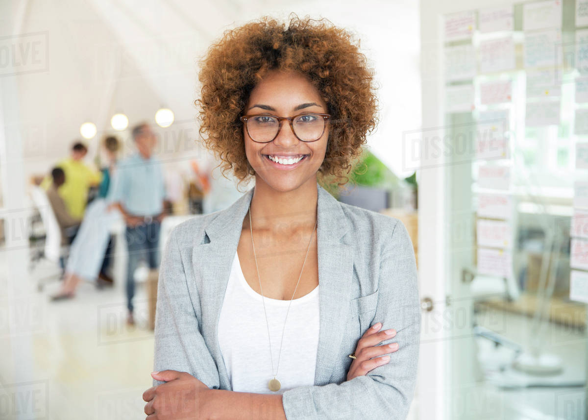 Portrait of smiling office worker with crossed arms - Stock Photo ...