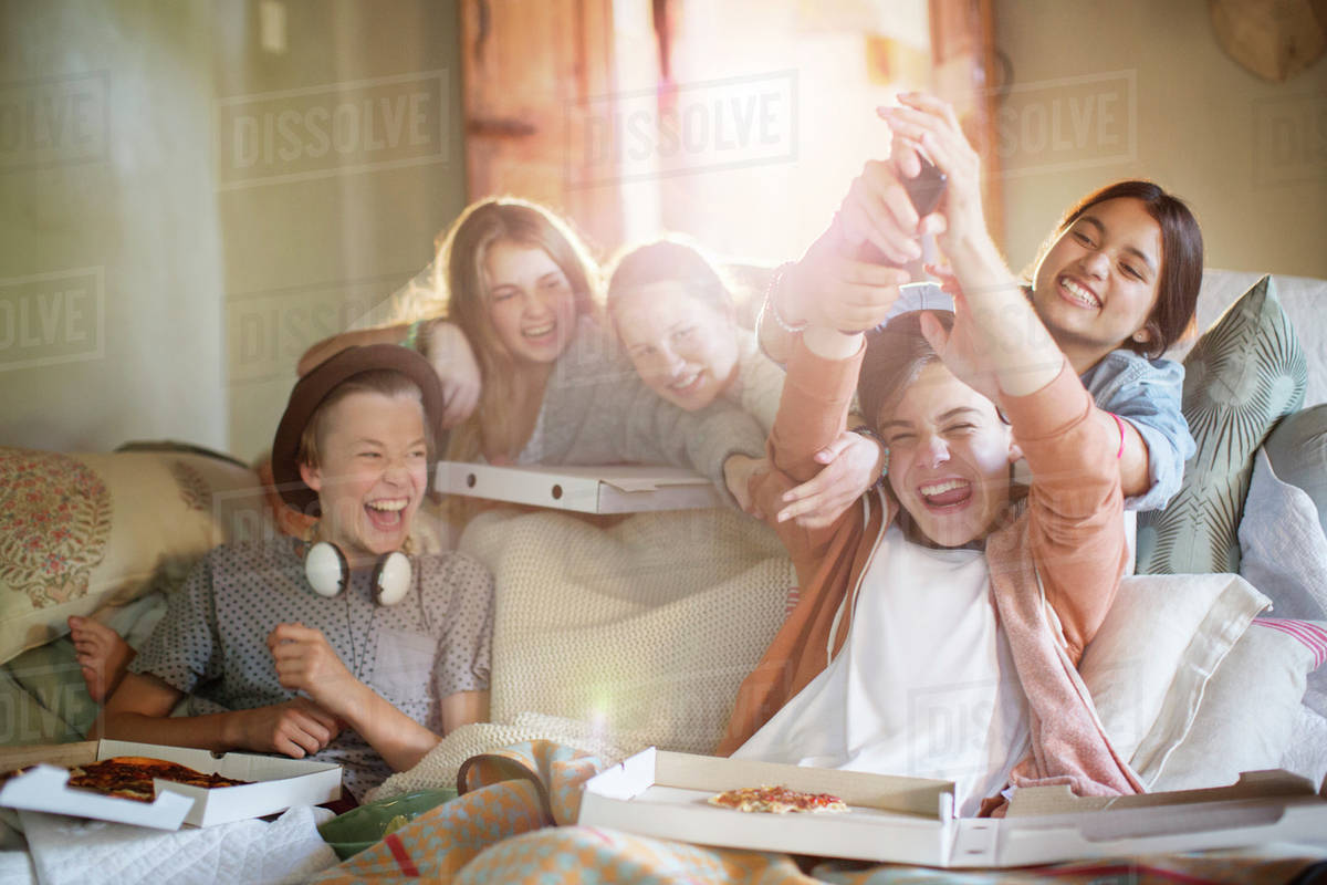 Group of teenagers having fun while watching tv on sofa - Stock Photo ...