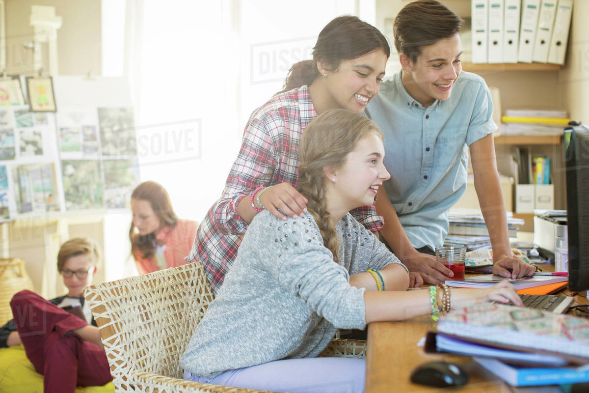 Teenagers sharing computer in living room - Royalty-free Stock Photo ...