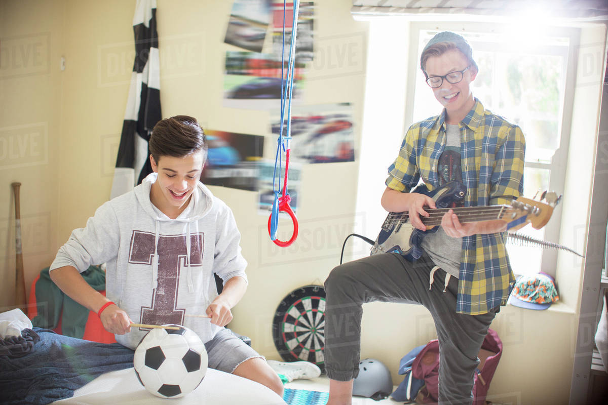 Two teenage boys playing music in room - Stock Photo - Dissolve
