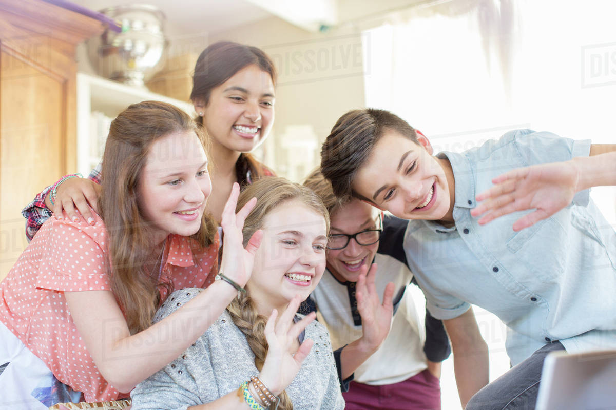 Group of teenagers waving while communicating via internet - Royalty ...