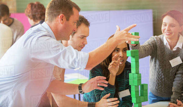 Business people stacking green blocks - Royalty-free Stock Photo | Dissolve