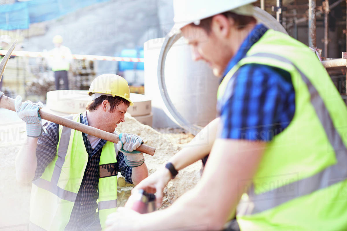 Construction workers digging at construction site - Stock Photo - Dissolve