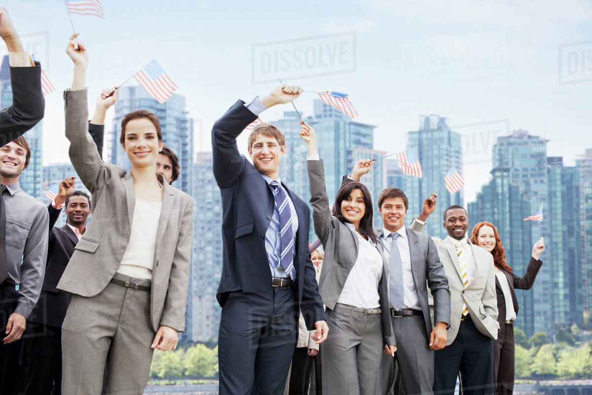 Portrait of smiling business people waving American flags - Royalty ...