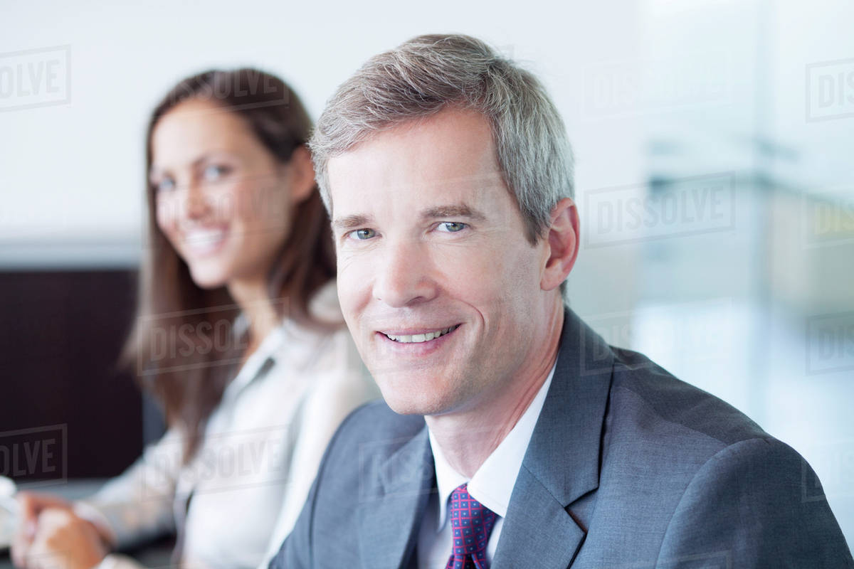 Businessman smiling in meeting - Stock Photo - Dissolve