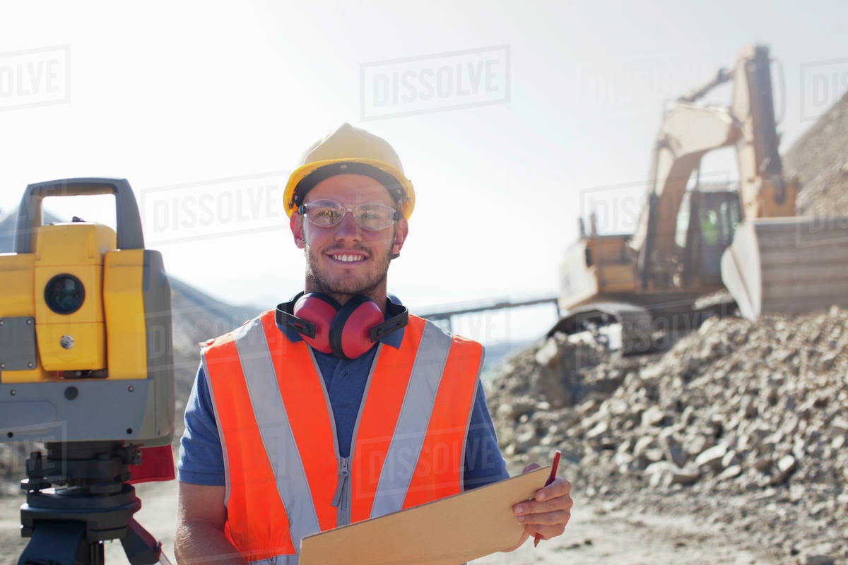 Worker using leveling equipment in quarry - Royalty-free Stock Photo ...