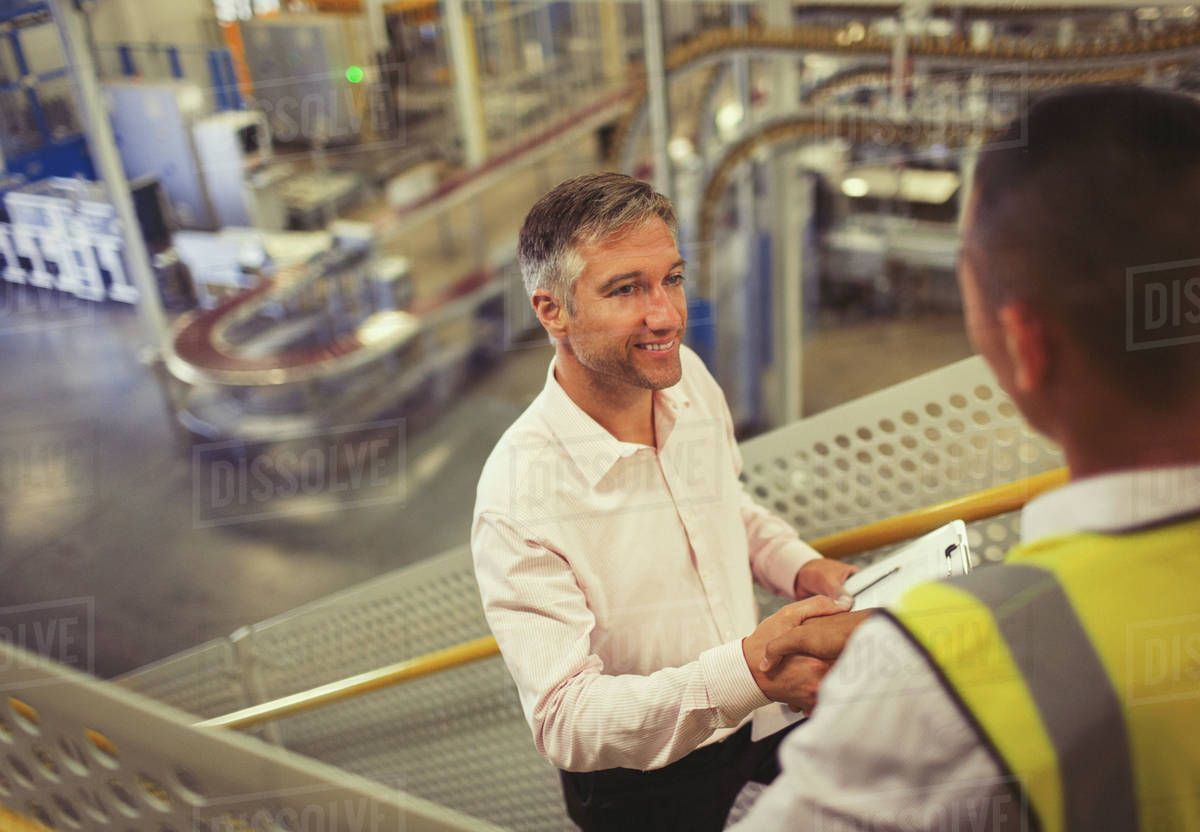 Supervisor and worker handshaking in factory - Royalty-free Stock Photo ...