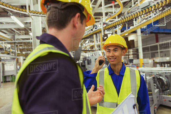 Workers talking in factory - Royalty-free Stock Photo | Dissolve
