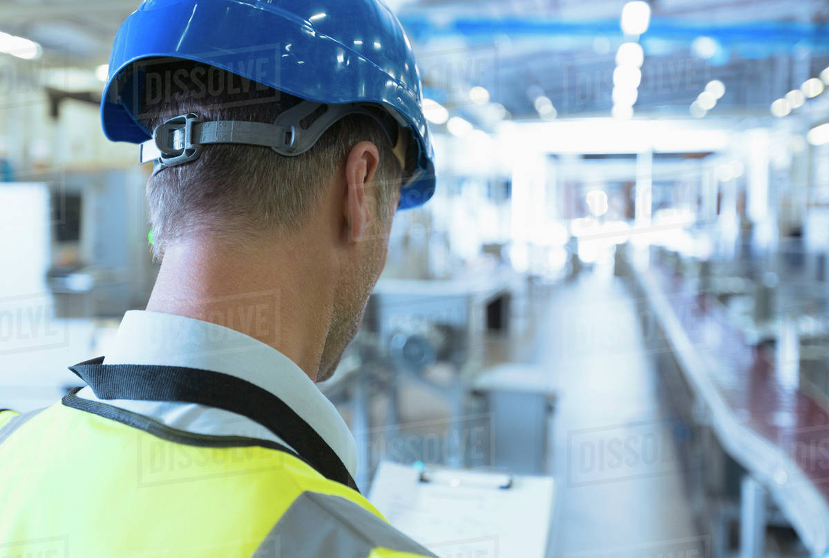Worker with clipboard in factory - Stock Photo - Dissolve