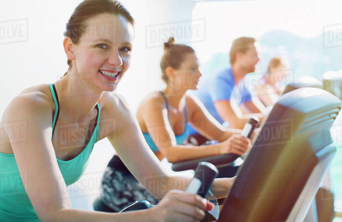 Portrait smiling woman riding exercise bike at gym - Royalty-free Stock ...