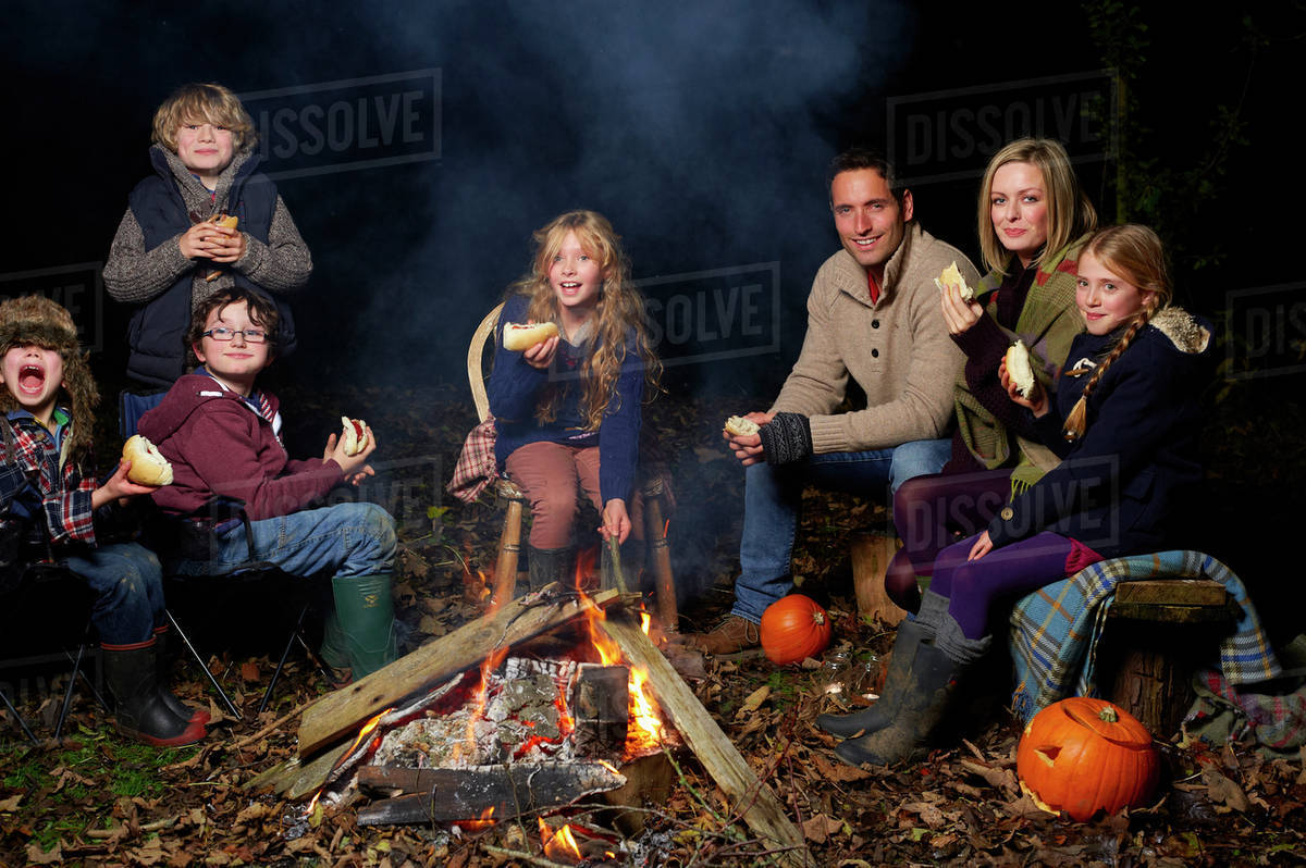 Family eating around campfire at night - Royalty-free Stock Photo ...