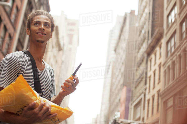 Man carrying mail on city street - Royalty-free Stock Photo | Dissolve