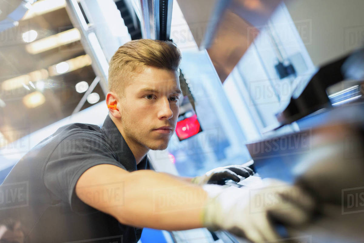 Worker operating machinery in steel factory - Stock Photo - Dissolve